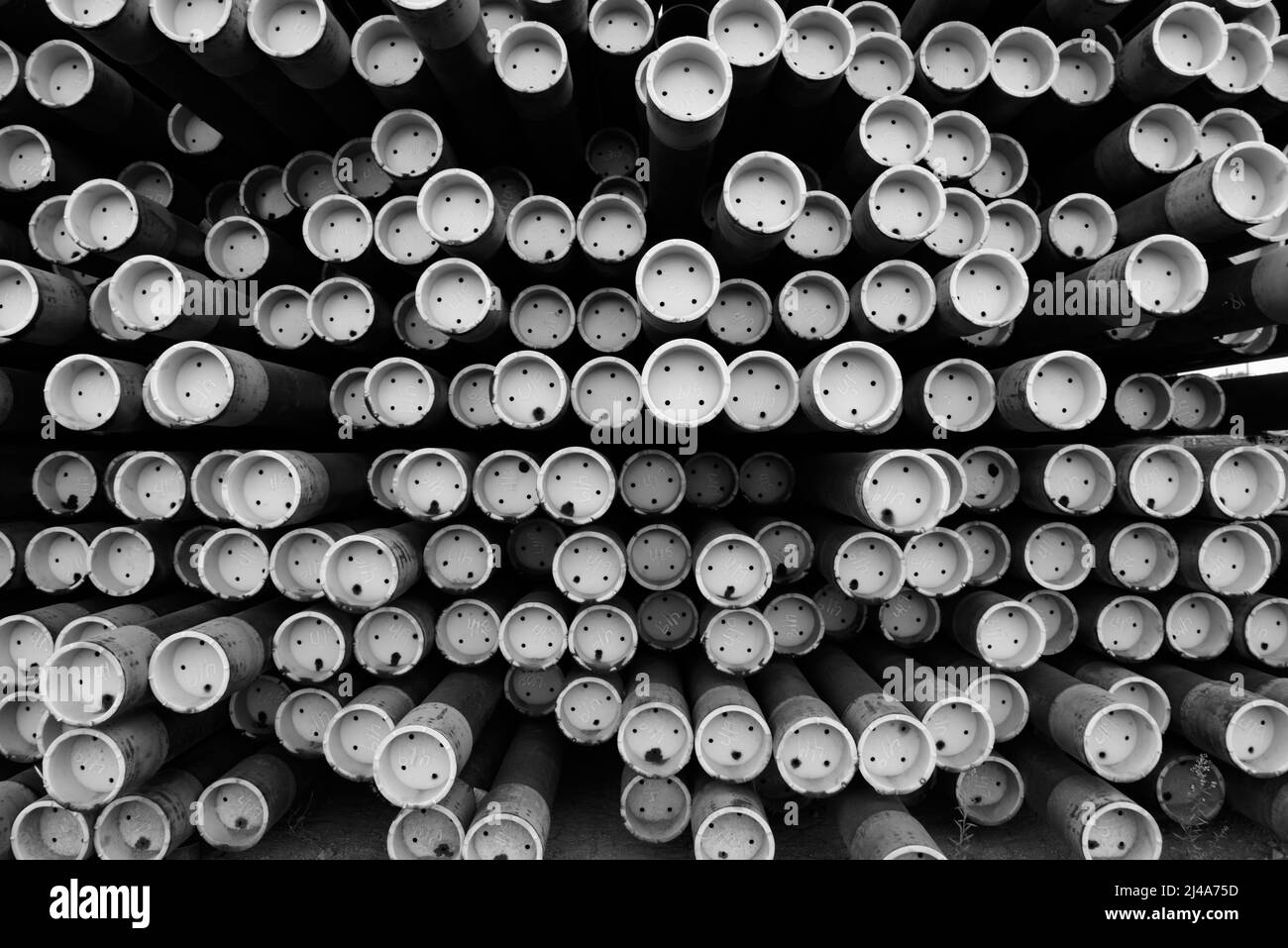 Close up side view of rows of stacked oil and gas industry iron metal ...