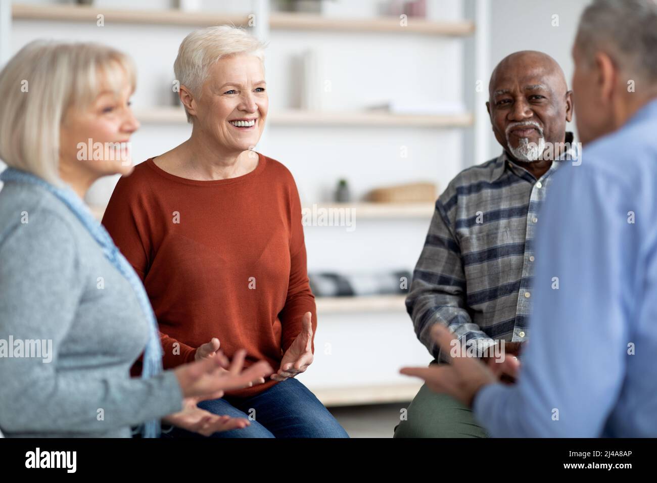 Excited multiethnic elderly people attending group therapy session ...