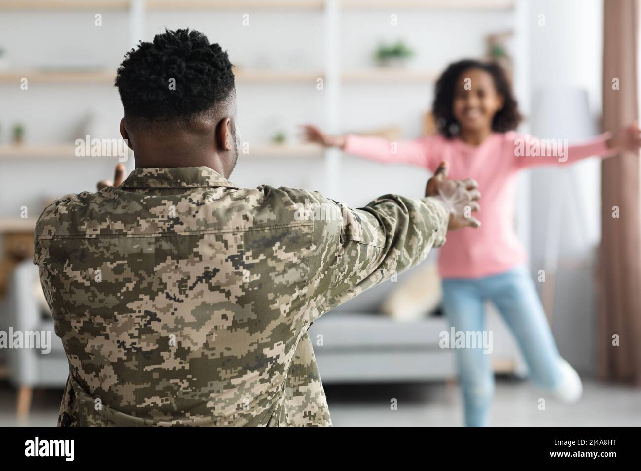 Happy black girl running into her dad soldier arms Stock Photo - Alamy