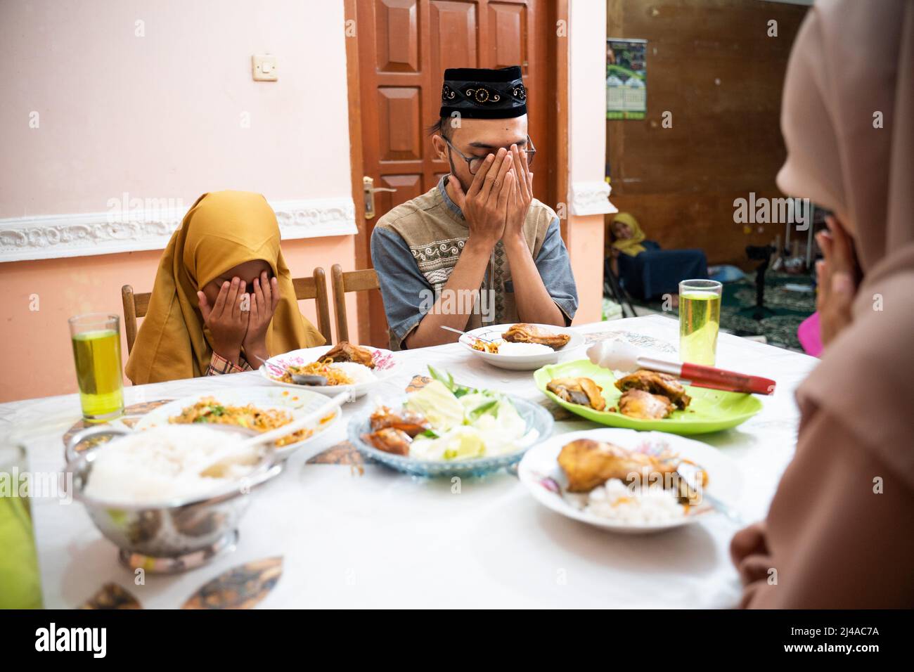 muslim family pray and thanking god for the food while breaking the ...