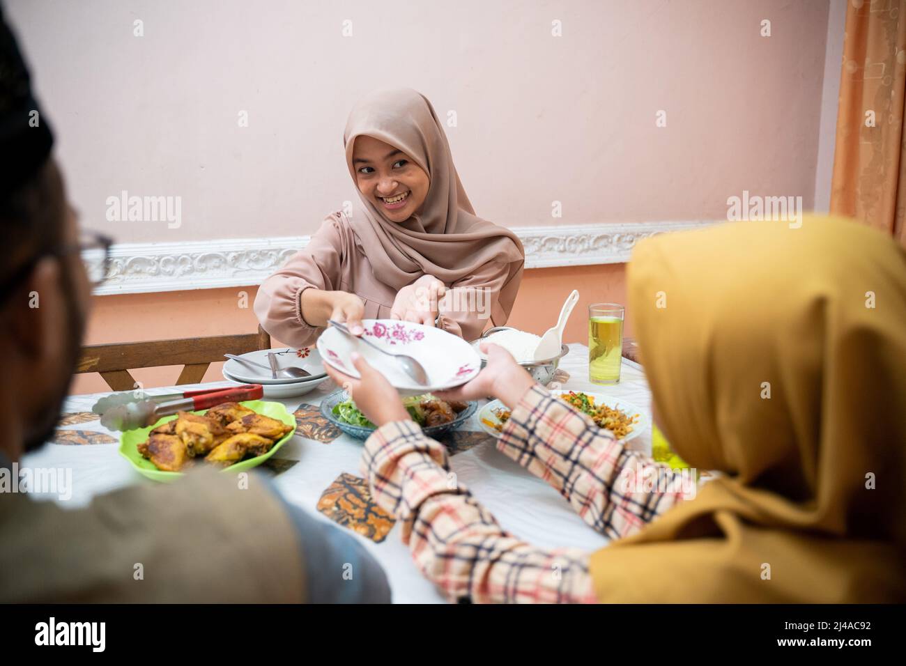 muslim mother serving some food for family dinner Stock Photo - Alamy