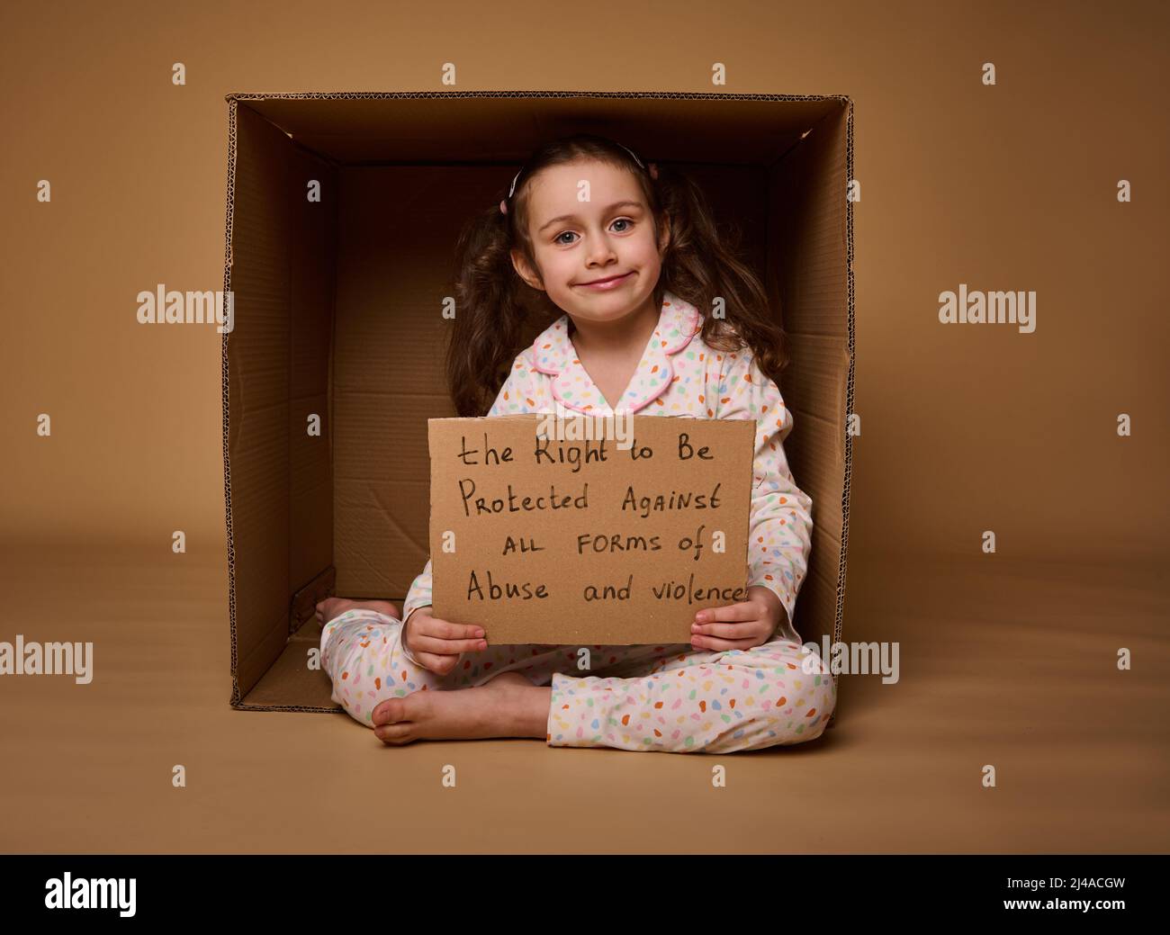 Adorable little Caucasian girl holding a poster with a message to be ...