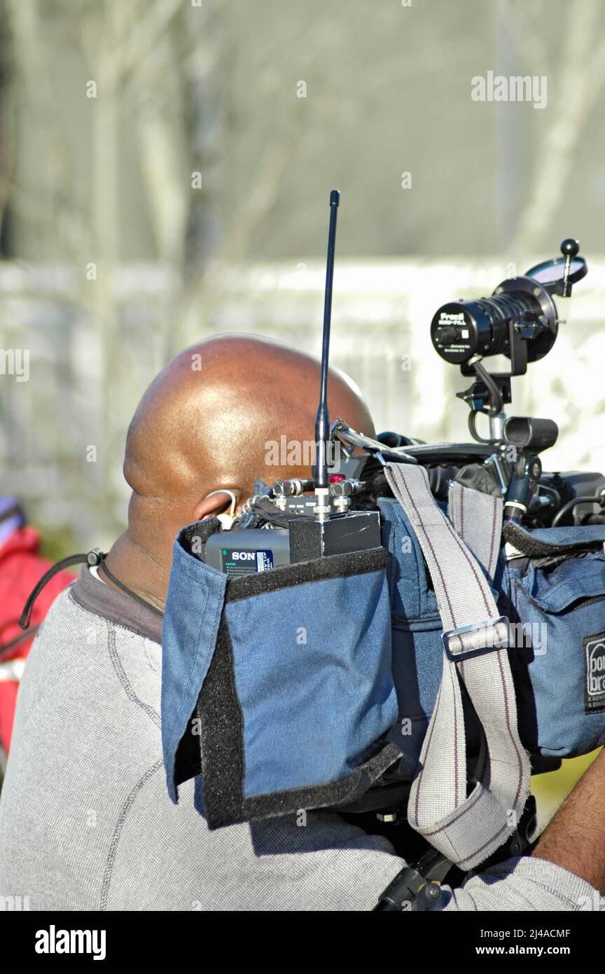 Television camerman photojournalist in the field at event recording and ...
