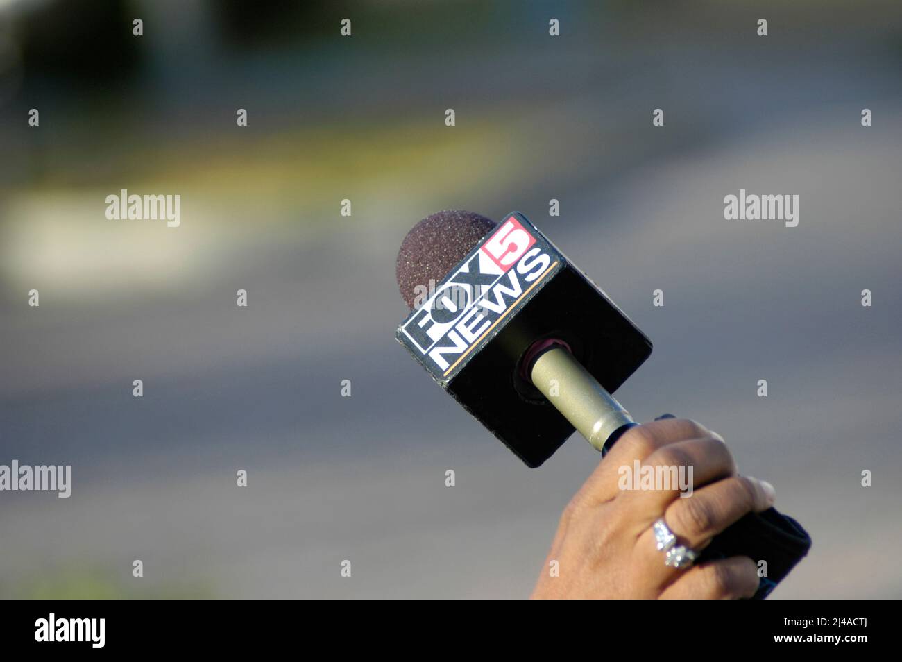 Television mic during interview by TV talking head at protest ...