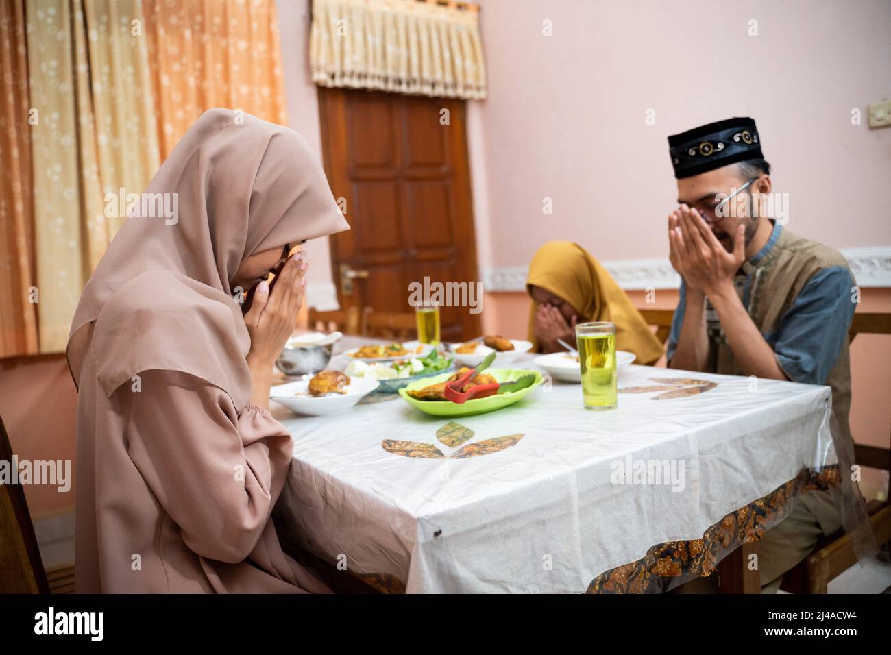 muslim family pray and thanking god for the food while breaking the ...