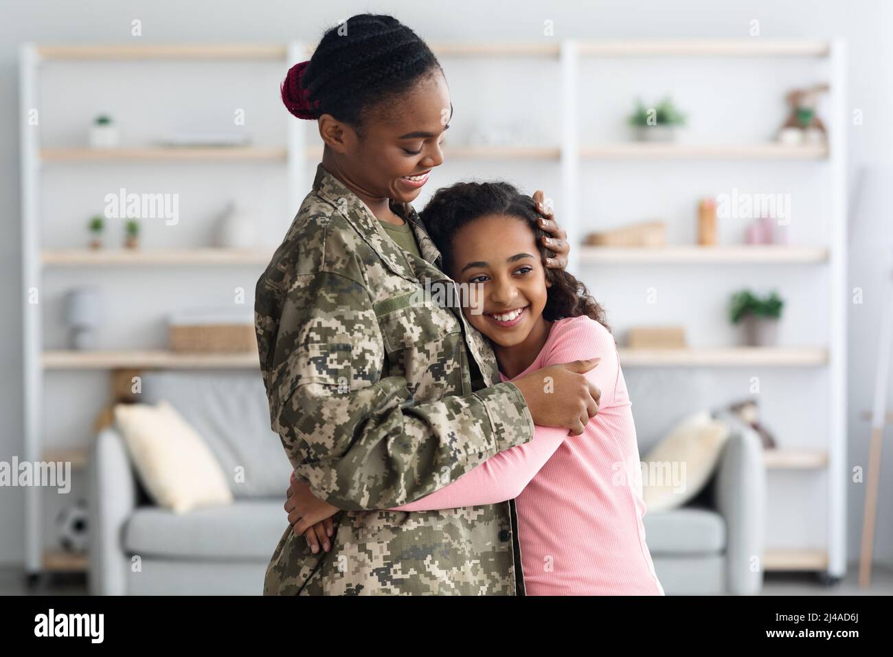 Adorable african american girl hugging her mother soldier Stock Photo ...