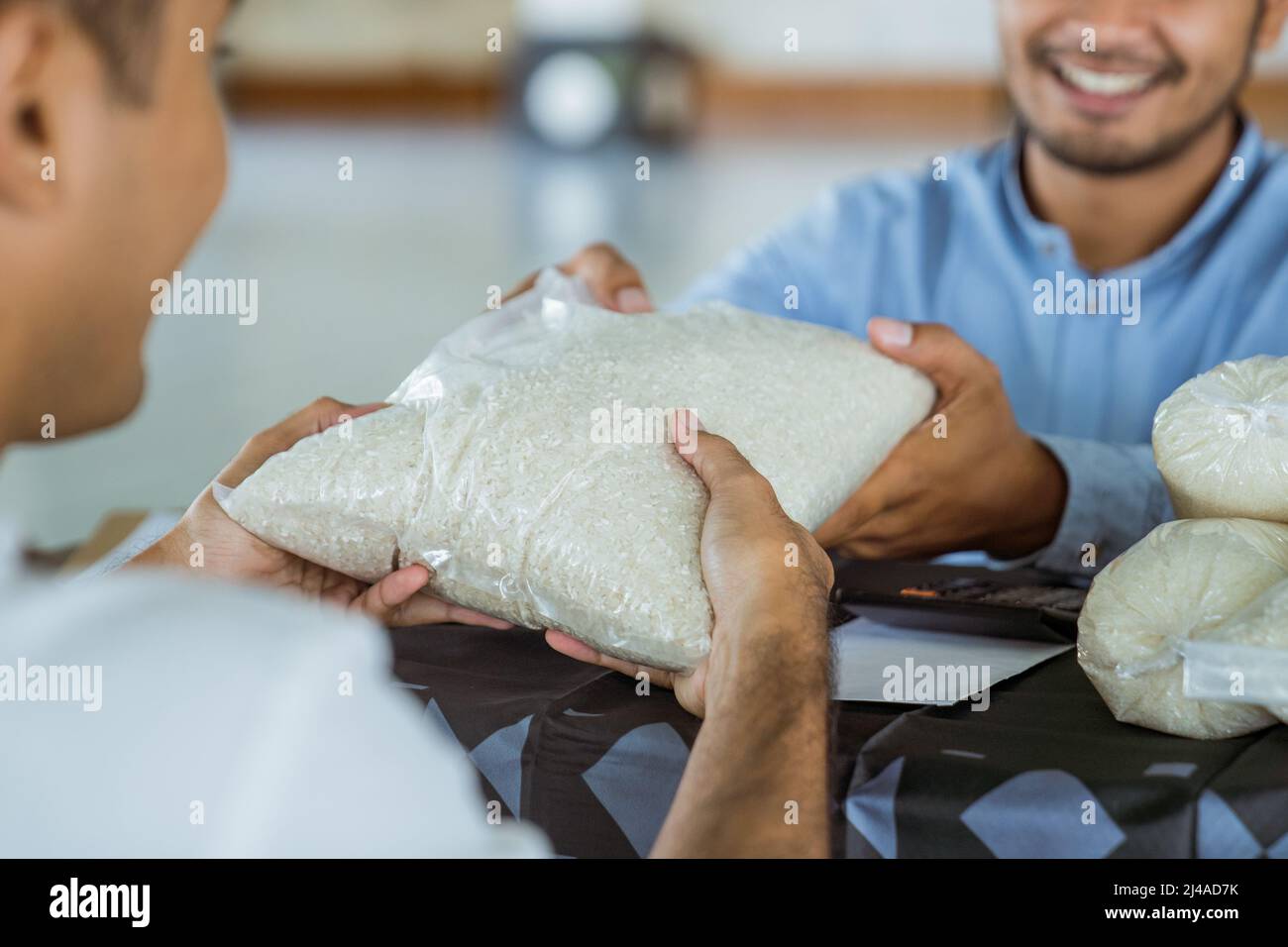 muslim man giving a rice as a food donation for zakat during eid ...