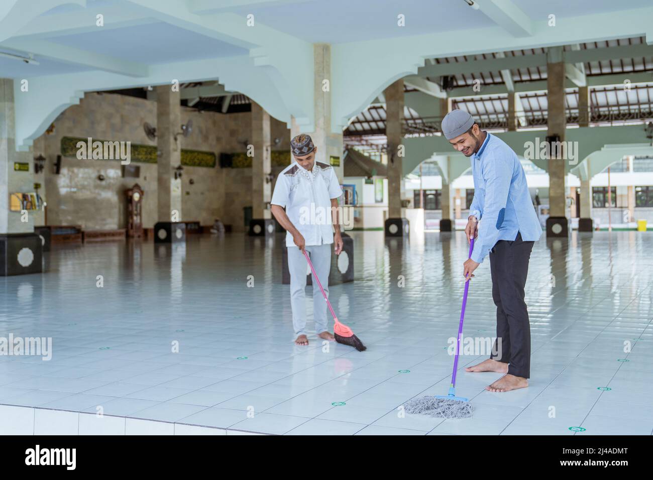 muslim male cleaning the mosque using broom and sweeping the floor ...