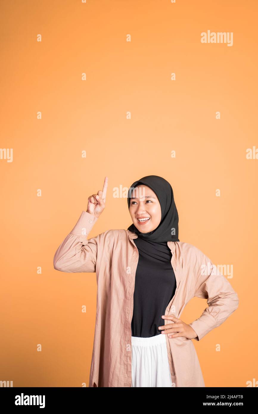 Smiling hijab woman with finger pointing up hand gesture Stock Photo ...