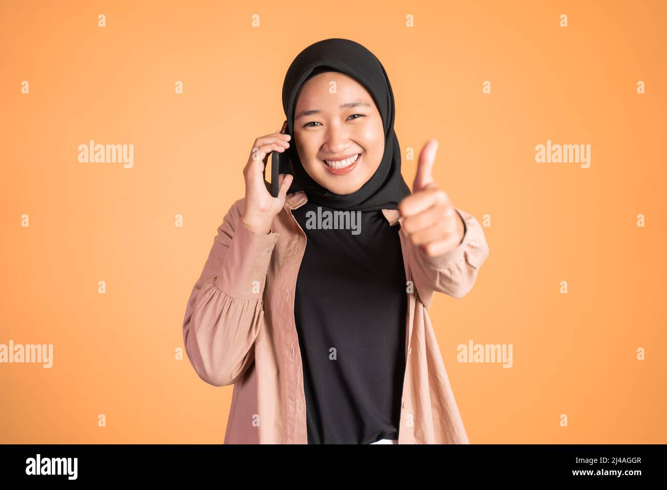 woman making a call using a cell phone and showing thumb up Stock Photo ...