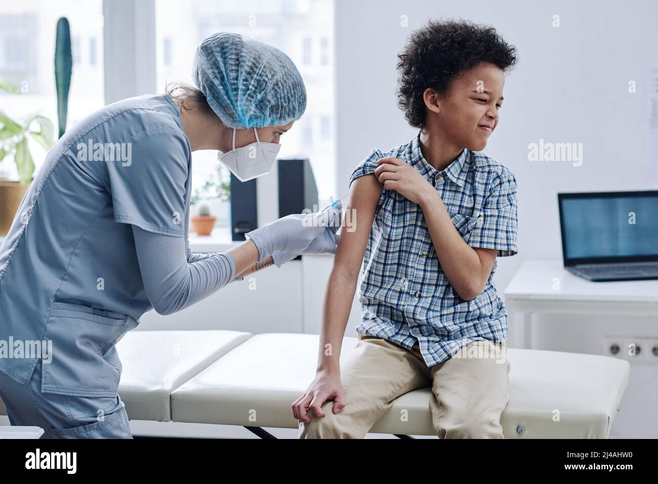 African little boy feeling pain while nurse giving an injection in his ...