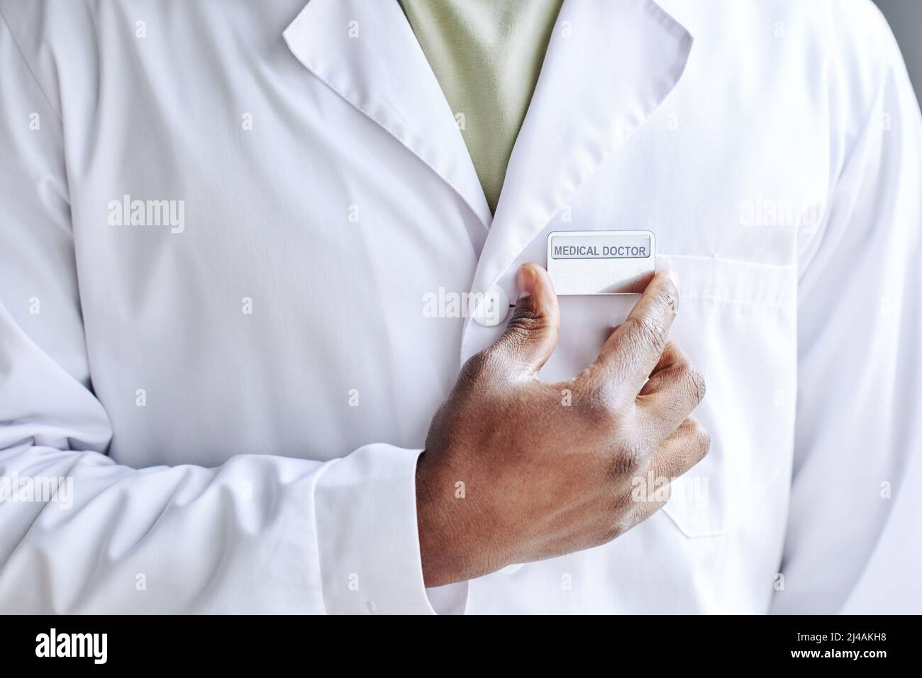 Close-up of African male doctor attaching badge on his white coat Stock ...
