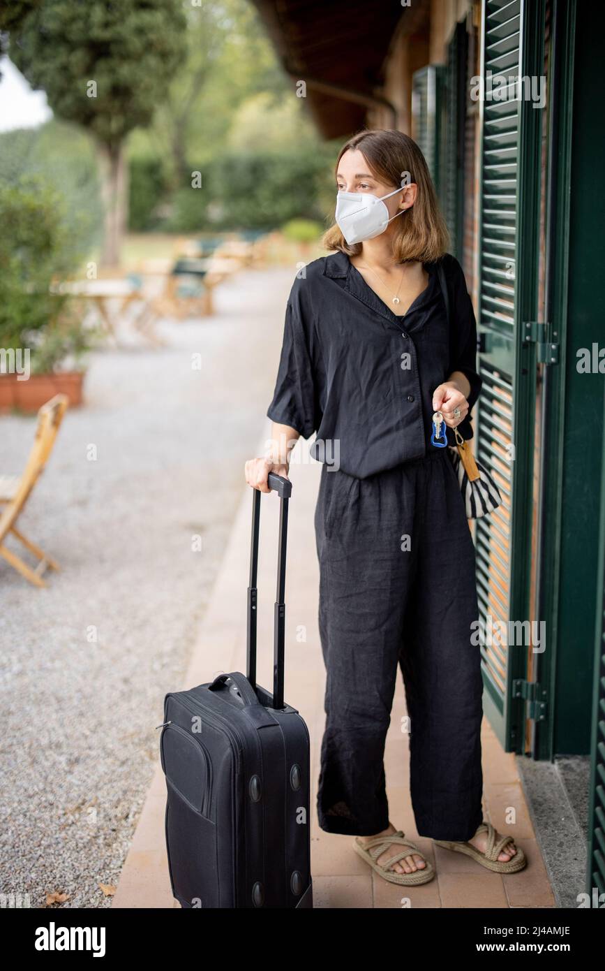 Girl in medical mask with baggage go in hotel room Stock Photo - Alamy