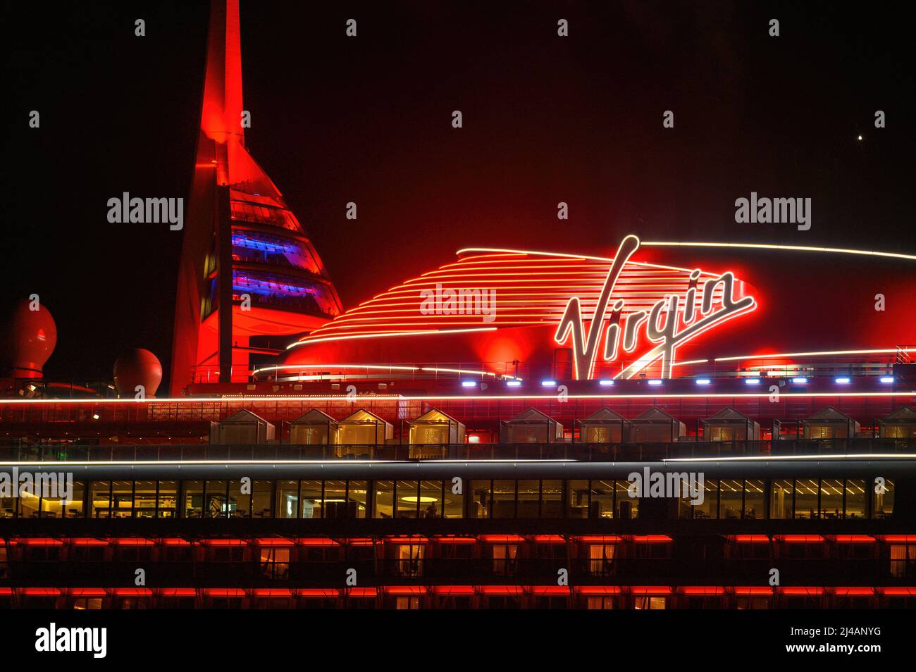 The Virgin Voyages logo lit in neon on the funnel of the cruise ship ...