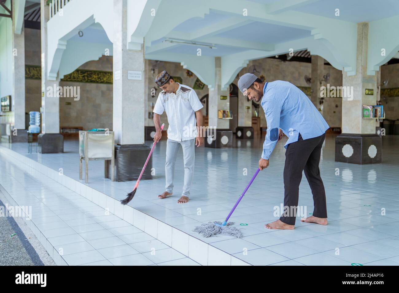 muslim male cleaning the mosque using broom and sweeping the floor ...