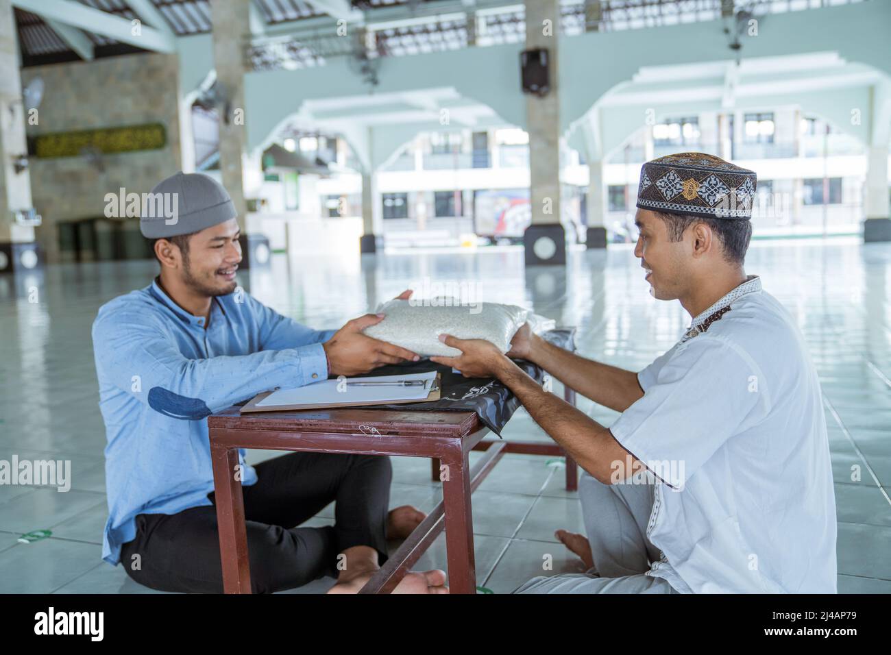 muslim man giving a rice as a food donation for zakat during eid ...