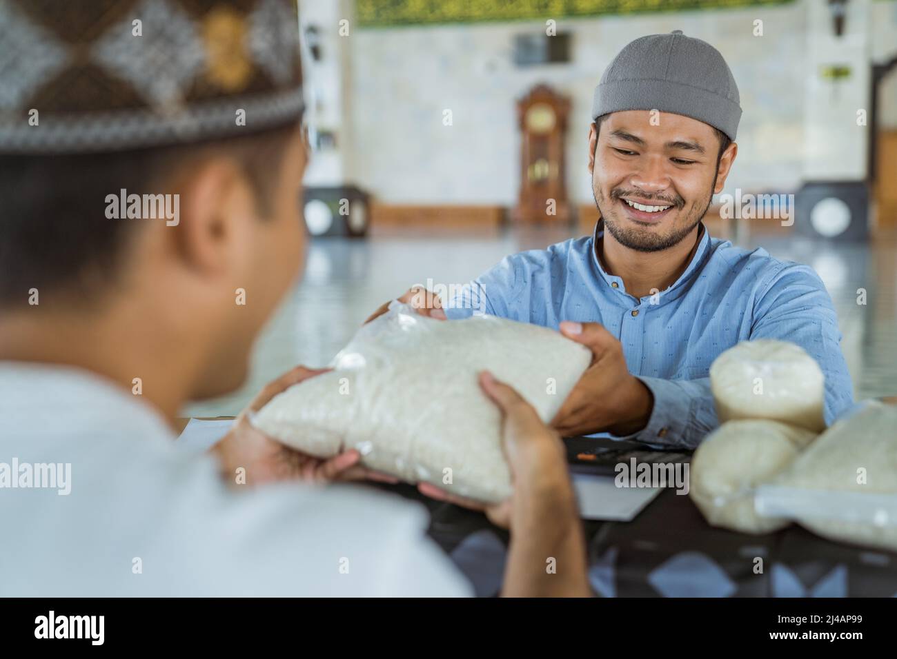 muslim man giving a rice as a food donation for zakat during eid ...