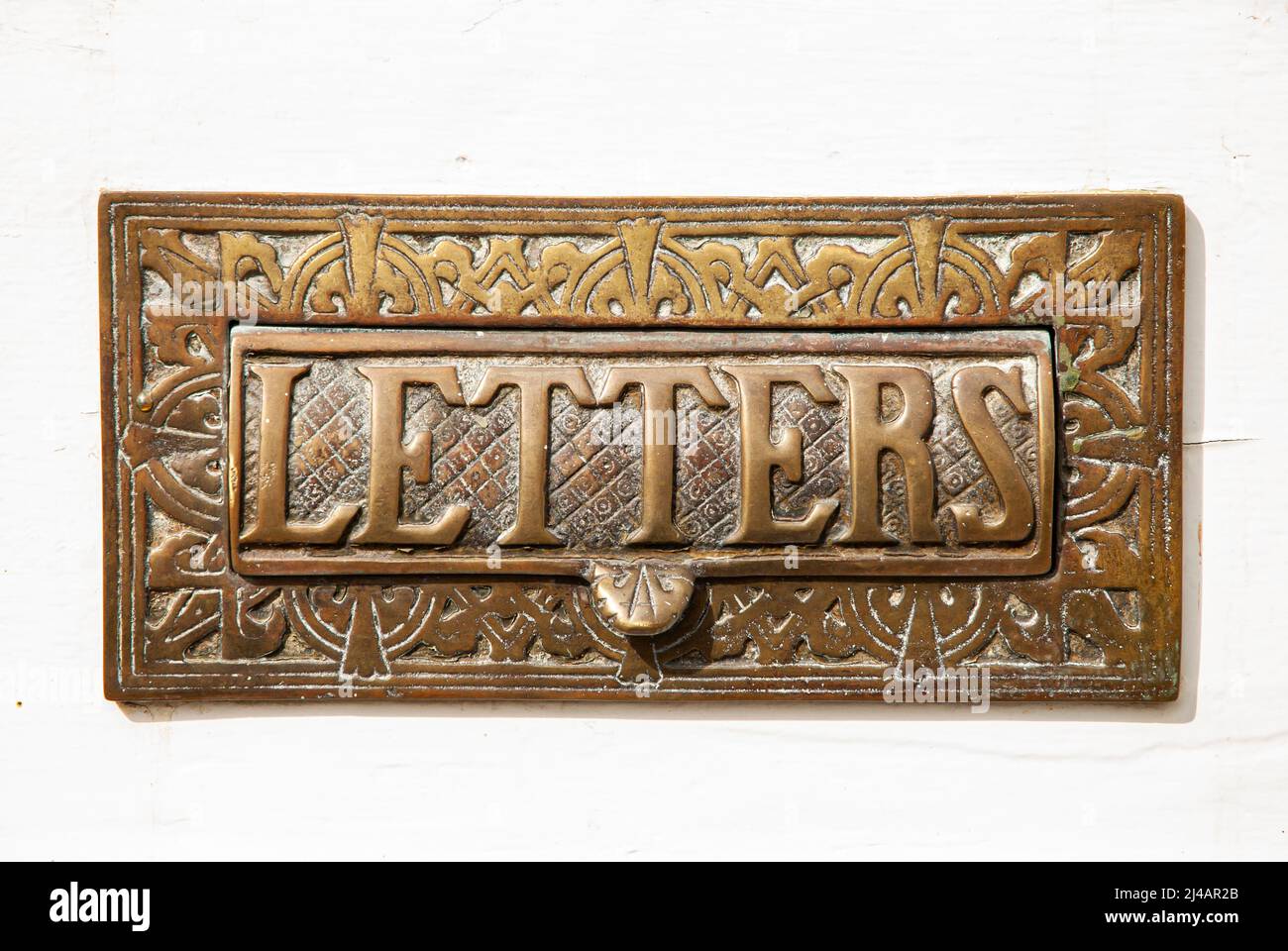 Old metal plate as hood of letter box in white wall Stock Photo - Alamy