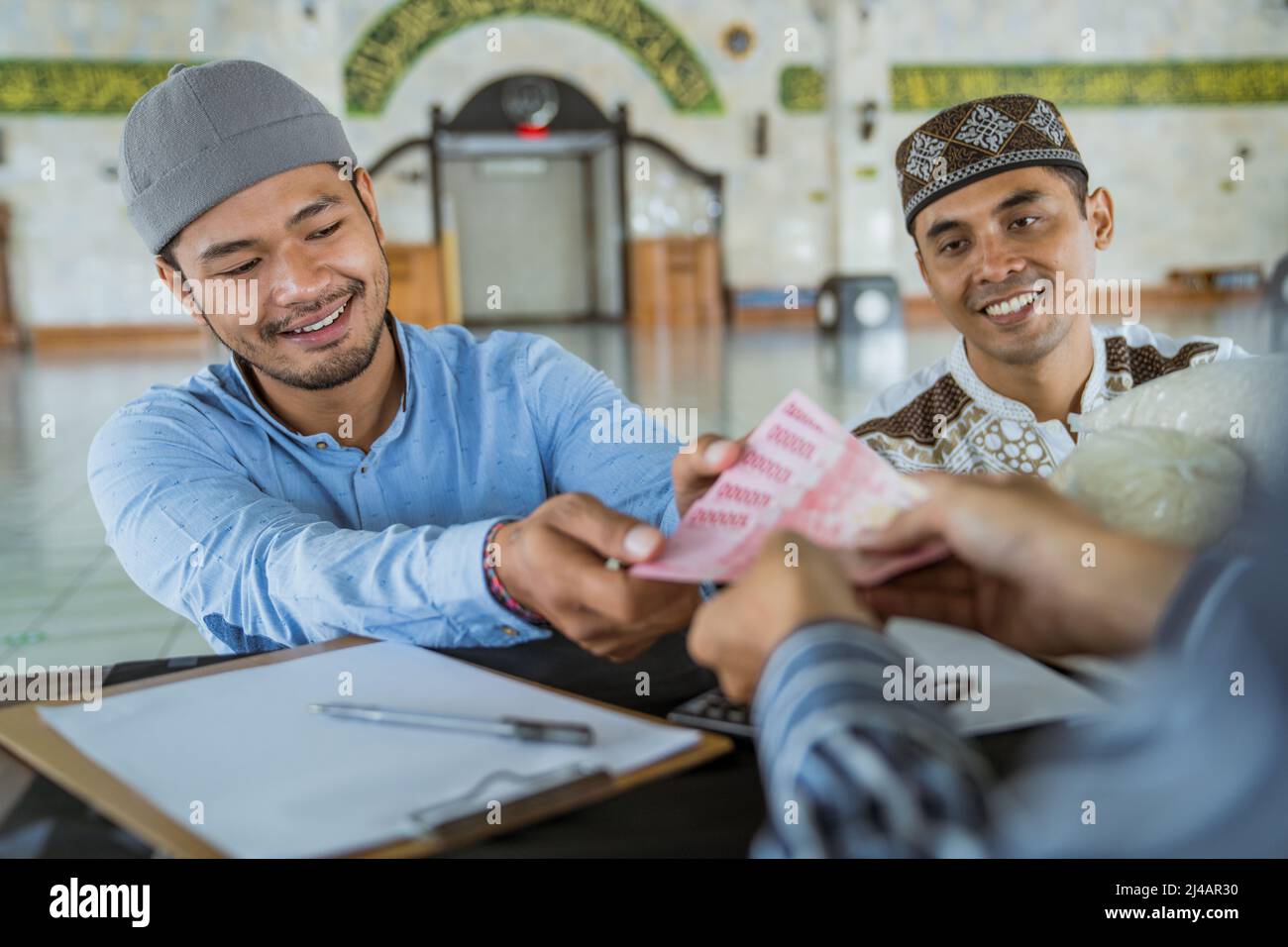 muslim paying some zakat charity using cash at the mosque Stock Photo ...