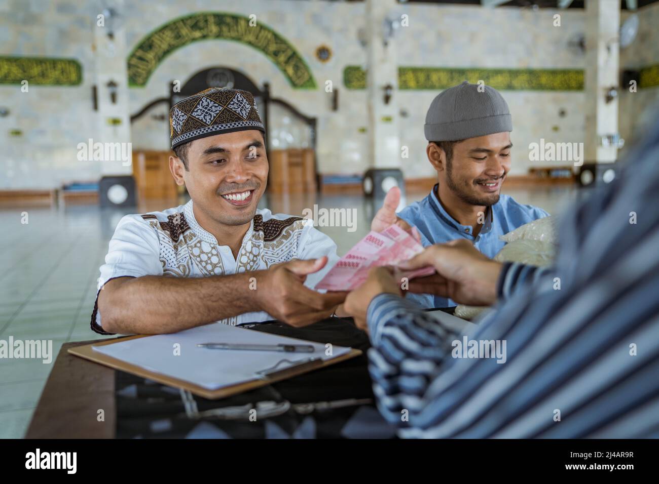 muslim paying some zakat charity using cash at the mosque Stock Photo ...