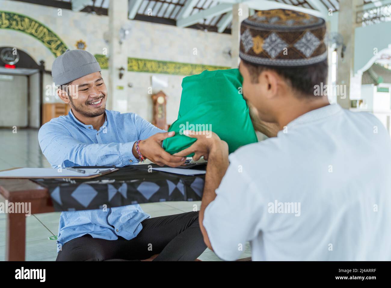 muslim man giving a rice as a food donation for zakat during eid ...