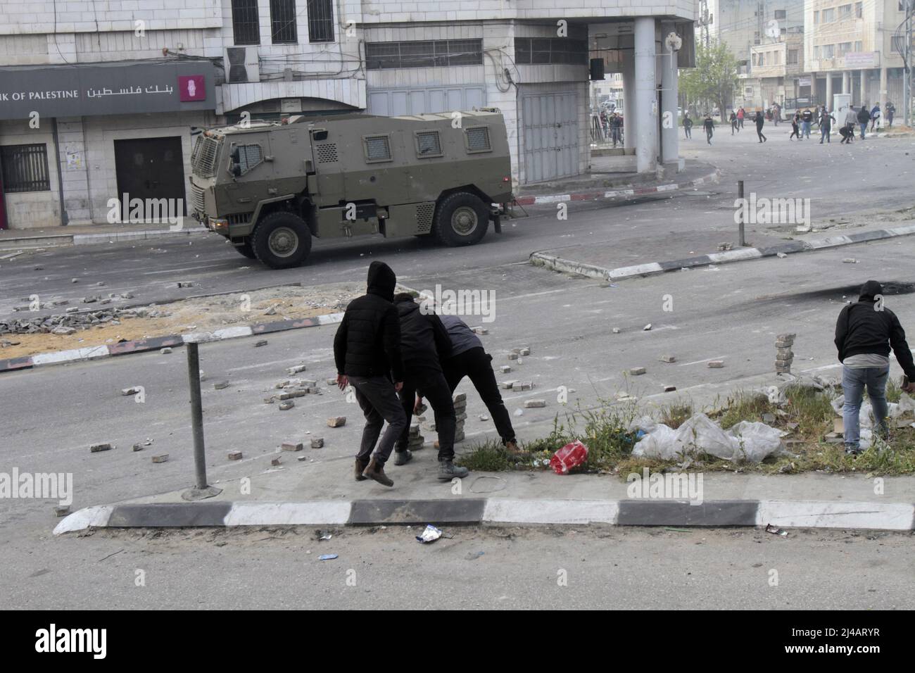 Palestinians throw stones at Israeli army vehicles as they protect ...