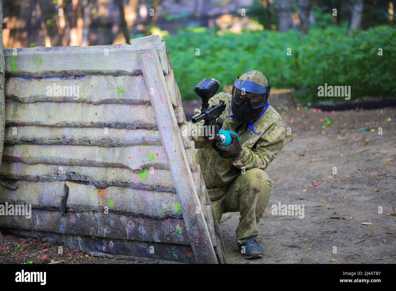 Paintball player in full gear shoots at the shooting range Stock Photo ...