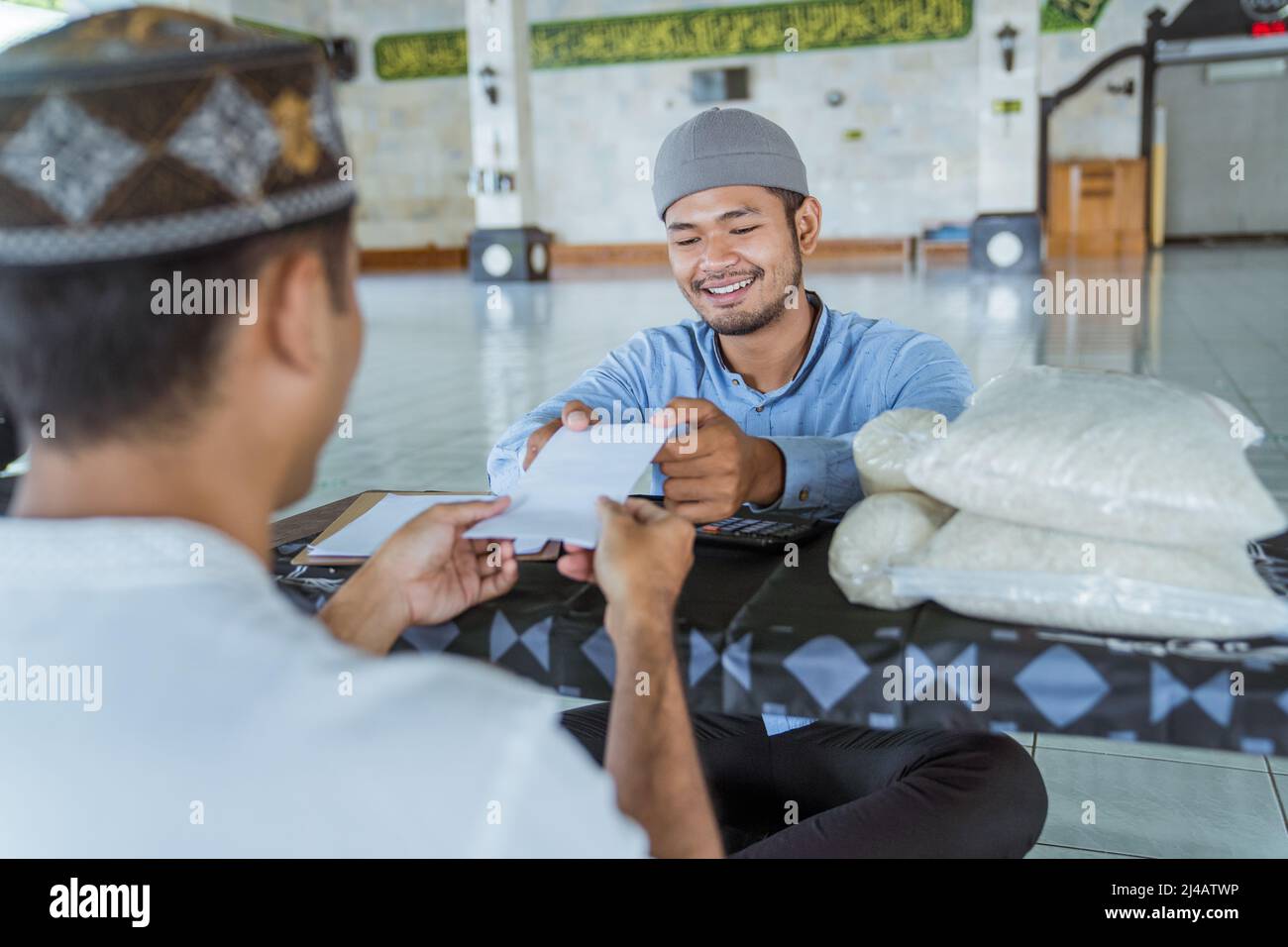 muslim man giving zakat charity for eid mubarak at the mosque Stock ...