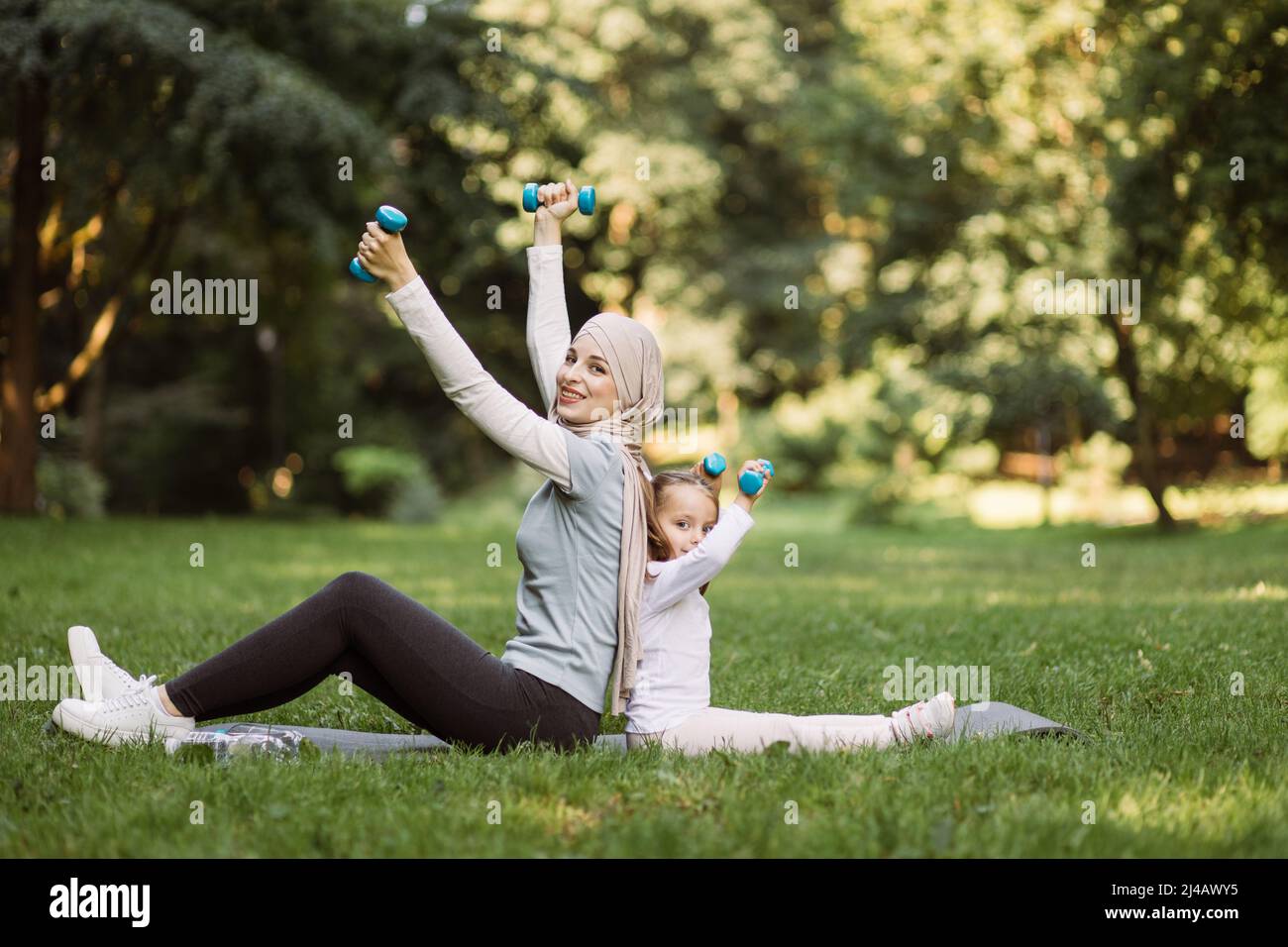 Family sport activity outdoors. Pretty sporty fit Muslim Arabian woman ...