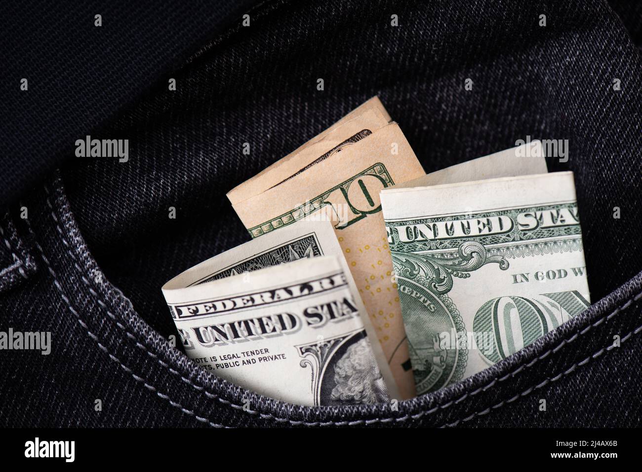 Three folded US Dollar Cash Paper Banknotes in black jeans pocket ...