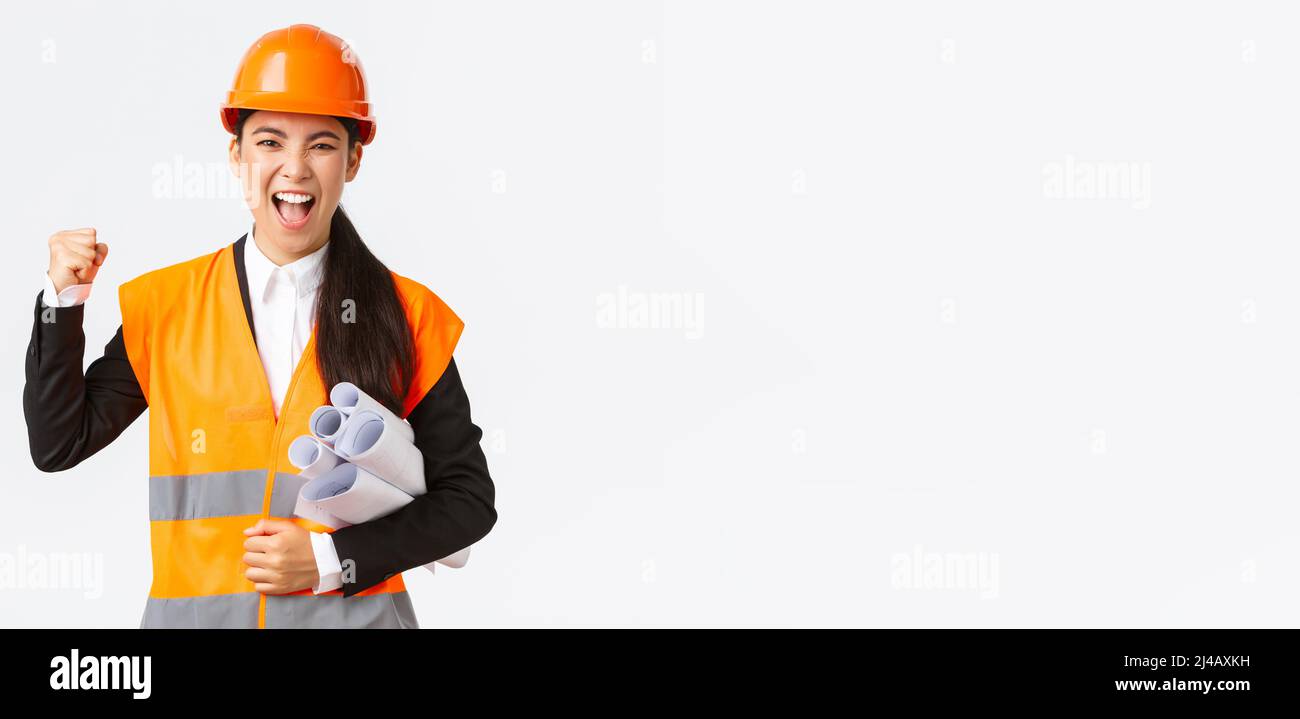 Successful female asian engineer, architect in safety helmet and ...