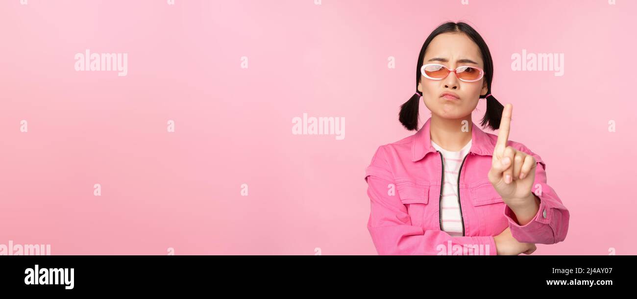 Image of serious, stylish asian girl in sunglasses, showing stop ...