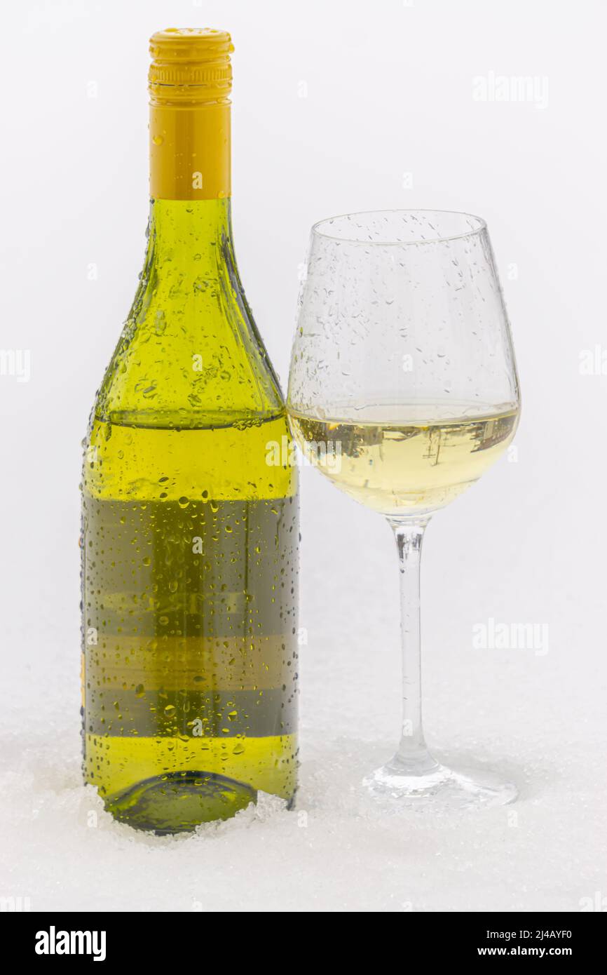 Bottle of white wine and a glass of wine in the freezing rain in the ...