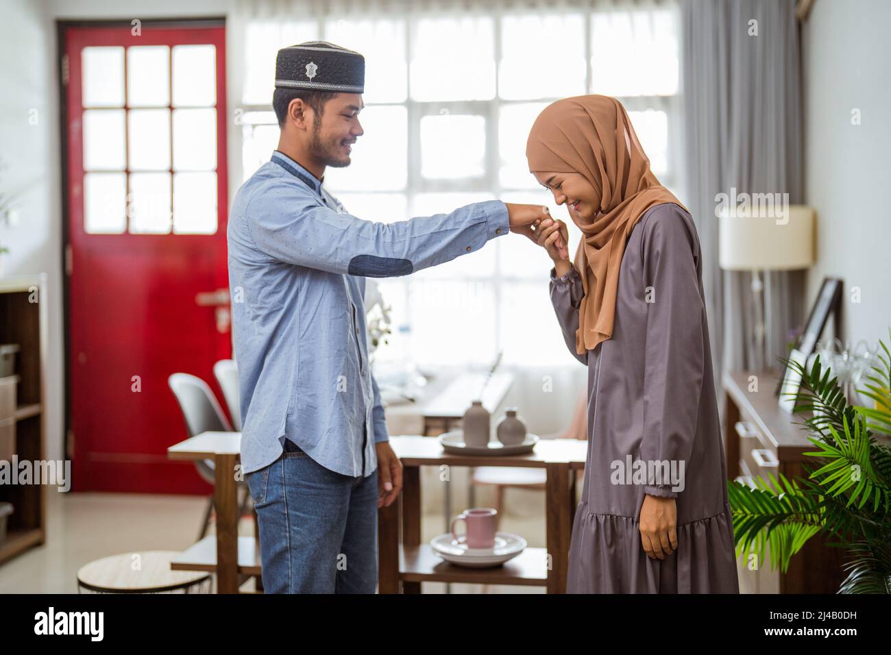 muslim woman shake hand and kiss her husband's hand Stock Photo - Alamy