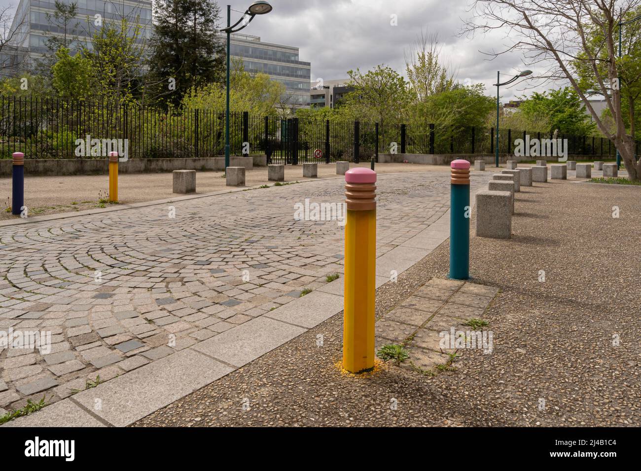 View of a paved road a pedestrian crossing a colored poles a park ...