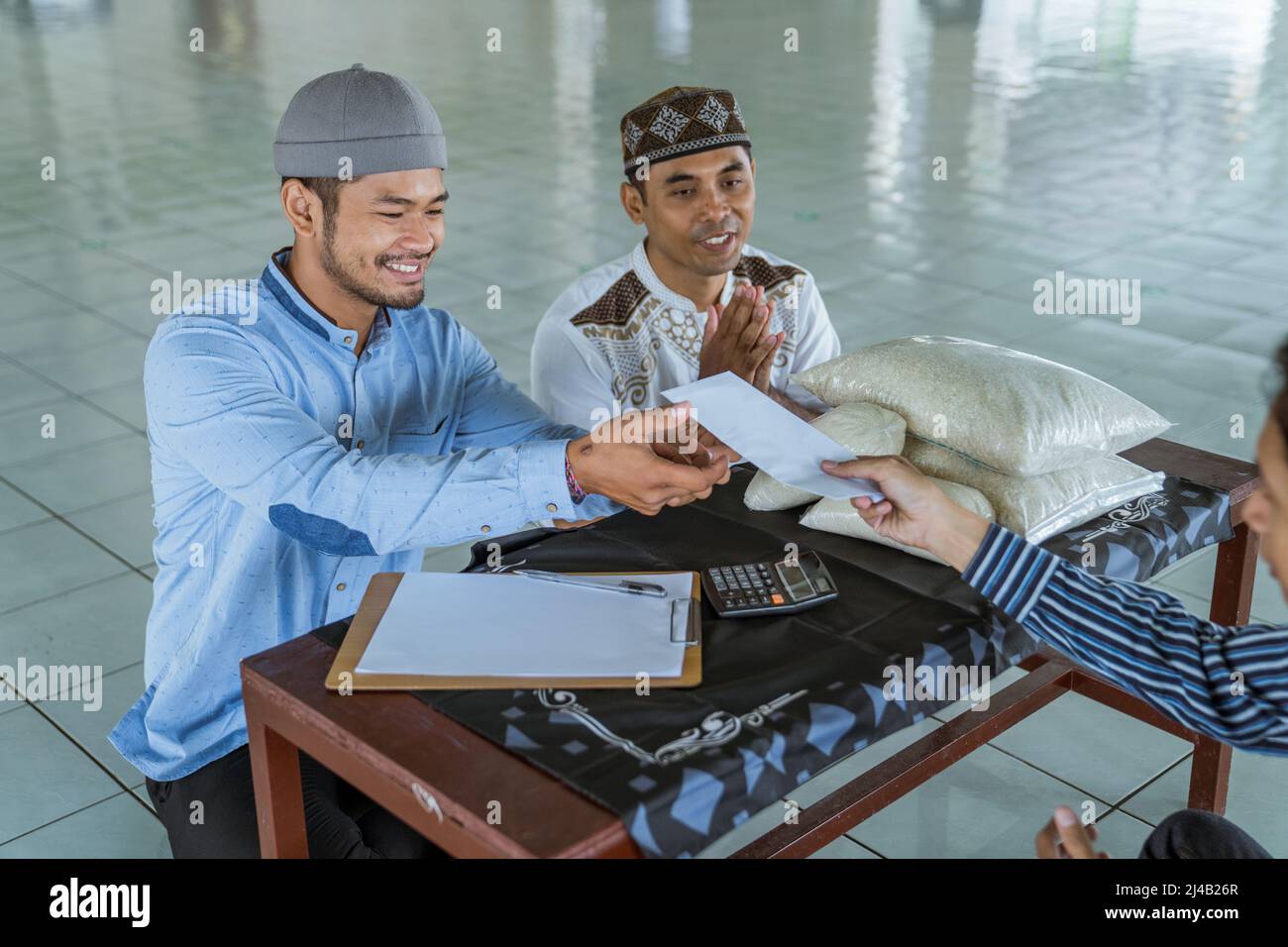 muslim man giving a rice as a food donation for zakat during eid ...