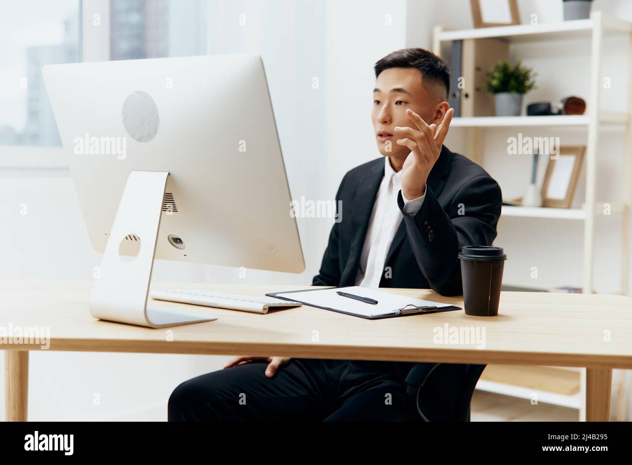 businessmen in a suit glass of coffee sits at a tablein front of a ...