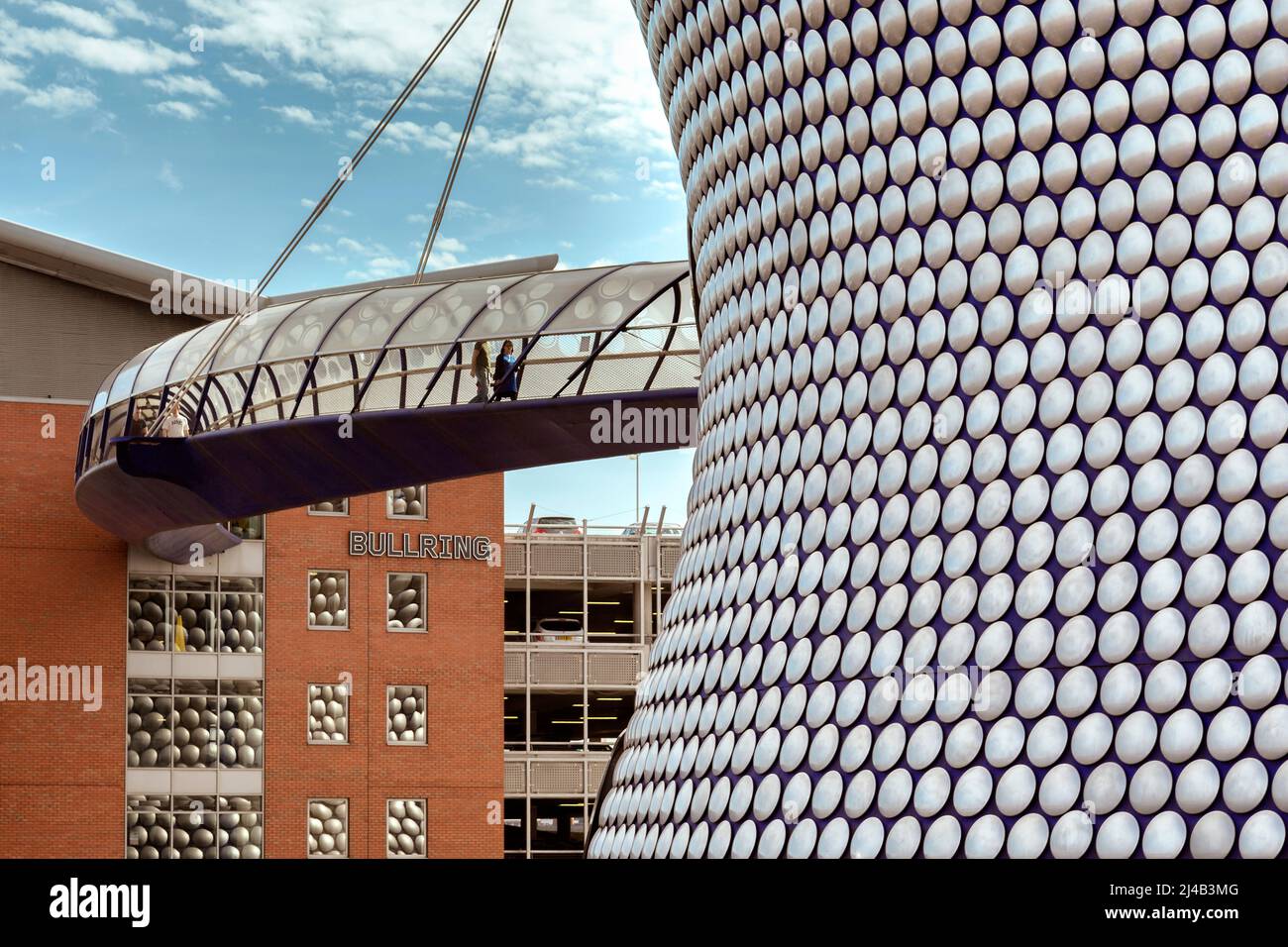 People cross the enclosed bridge from the car park to Selfridges store ...