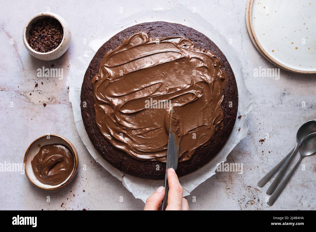 Icing being spread on to a chocolate cake Stock Photo - Alamy