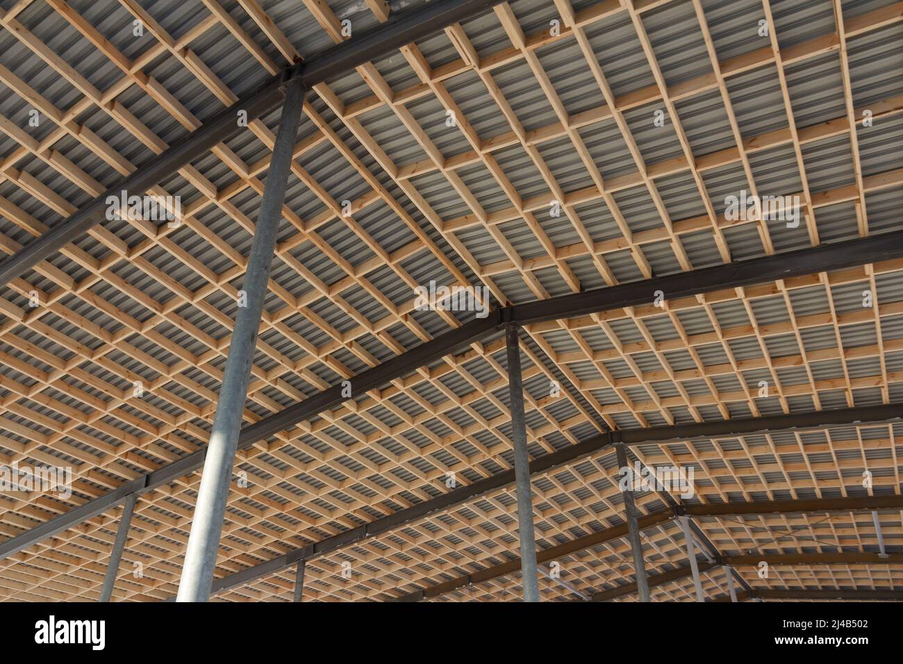 Timber frame roof construction in a barn under construction. Wooden ...