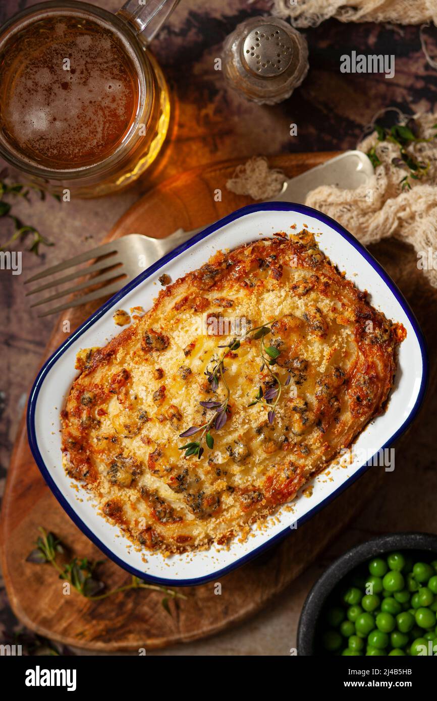 An individual steak and blue cheese pie topped with mashed potatoes and ...