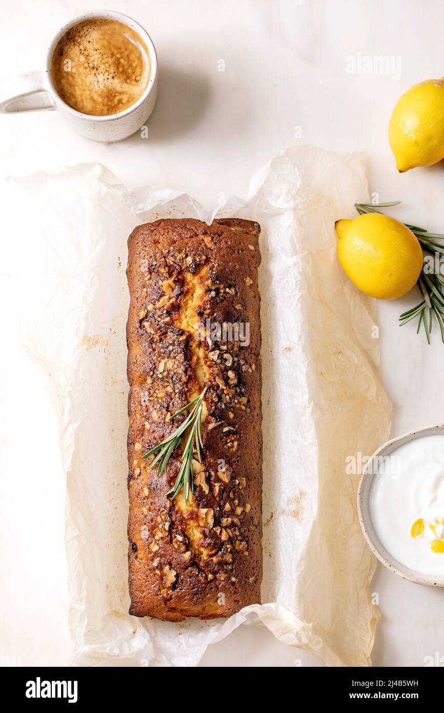 Whole Homemade lemon pound cake with nuts and rosemary on crumpled ...