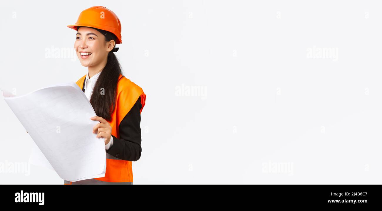 Satisfied happy asian female chief engineer looking at results of ...
