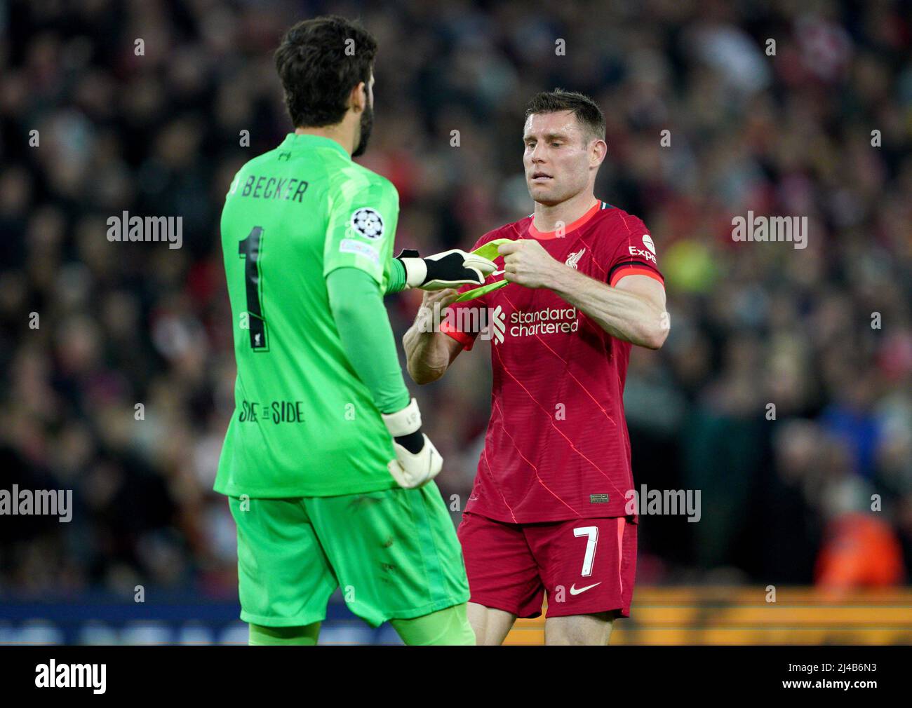 Liverpool's James Milner give the captains armband to goalkeeper ...
