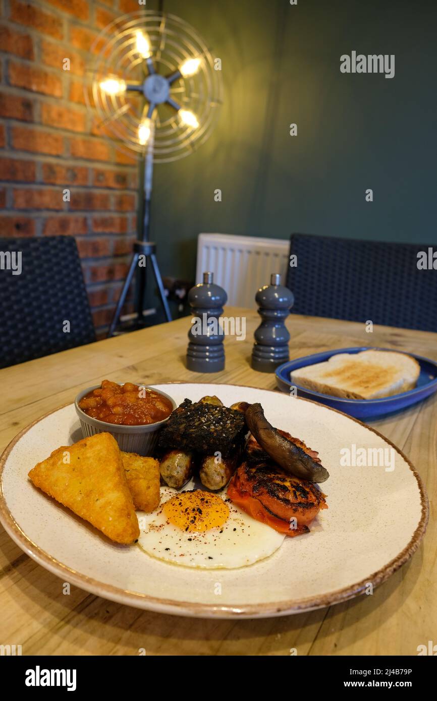 A full english breakfast with sausage bacon egg beans hash brown tomato ...