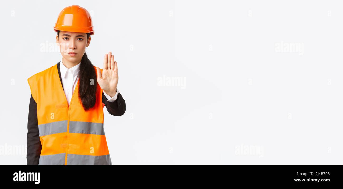 Serious-looking disappointed asian female architect, construction ...