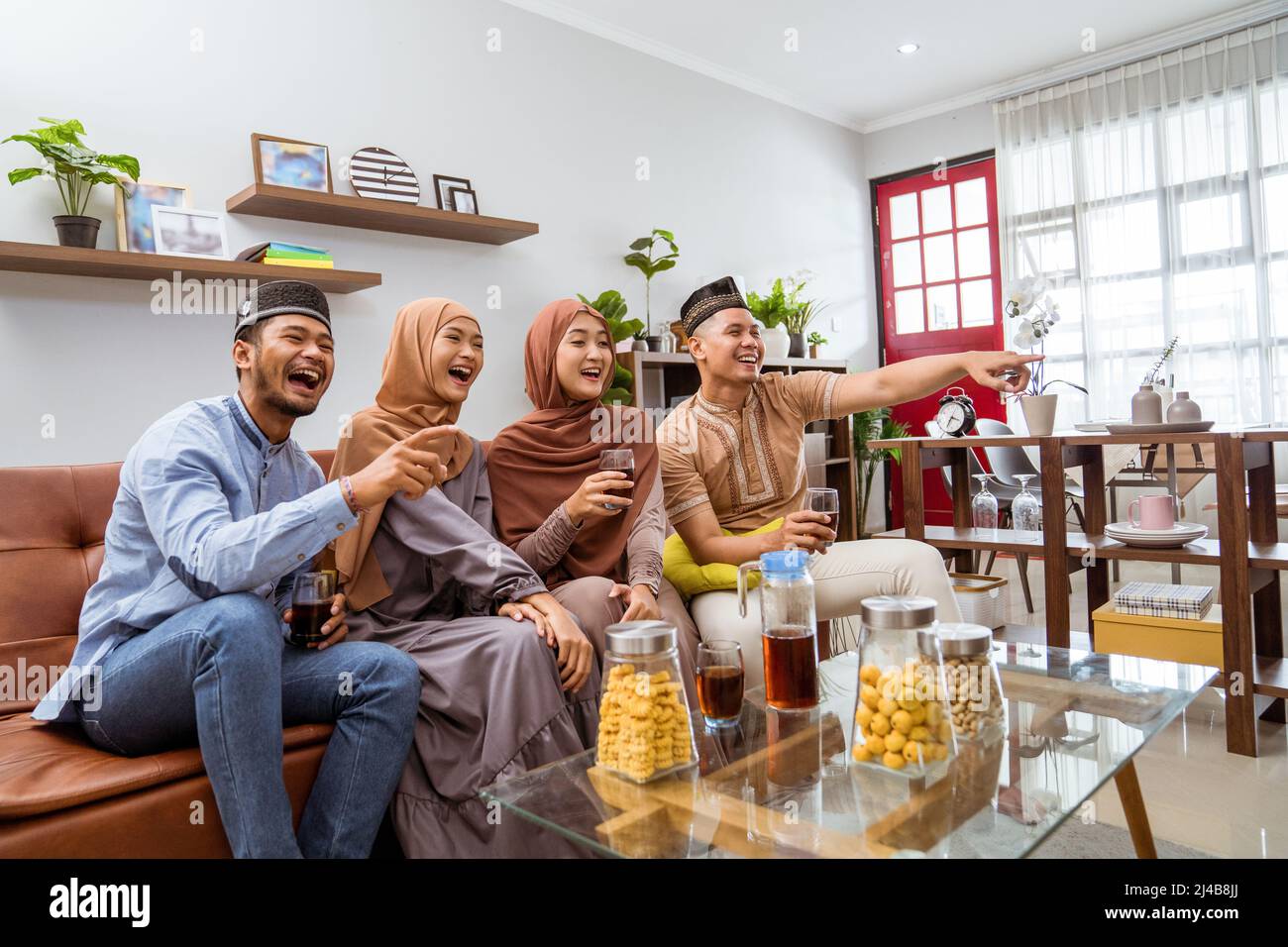 muslim friend sitting in livingroom enjoy watching tv Stock Photo - Alamy