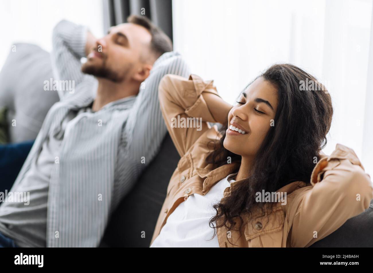 Relaxed happy couple enjoying of the rest at home on comfortable couch ...