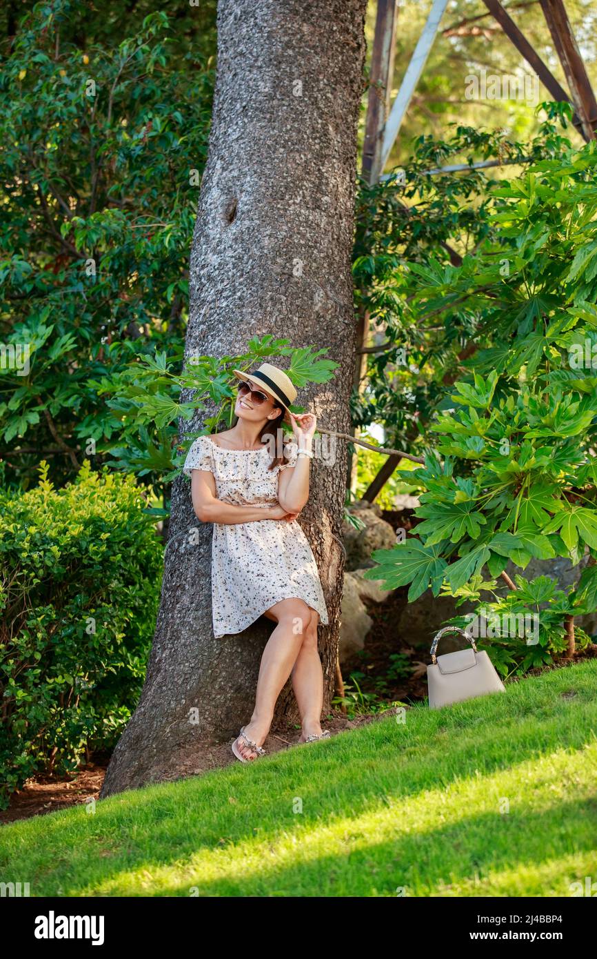 Woman standing under palm trees hi-res stock photography and images - Alamy