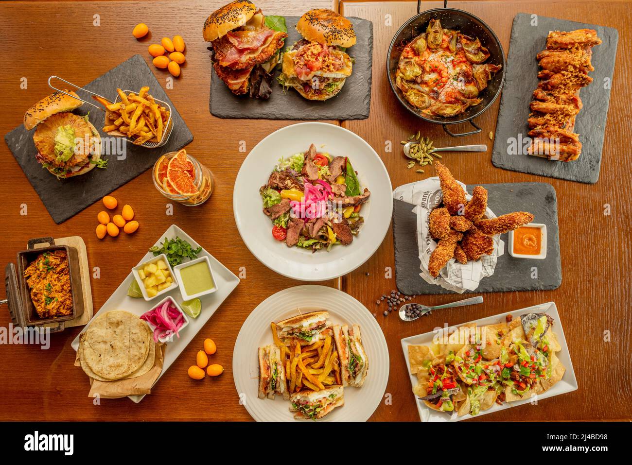 Set of homemade fast food dishes, sandwiches, Mexican al pastor tacos ...